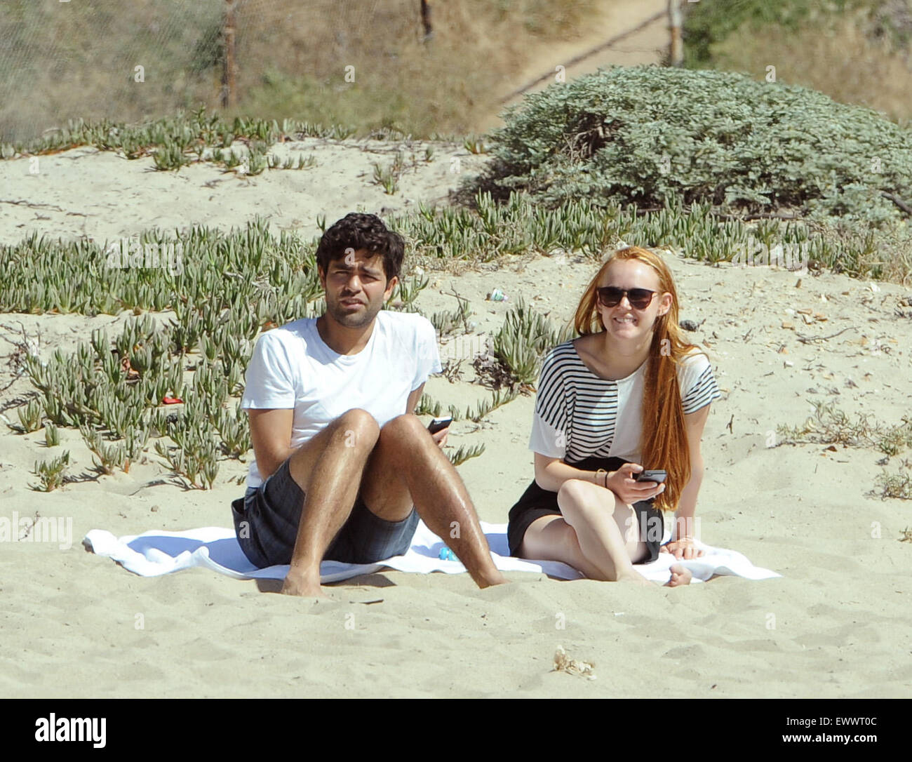 Actor Adrian Grenier enjoys a hot day on the beach with a gal pal in ...