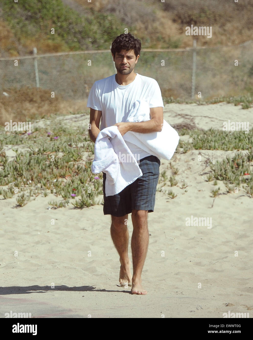 Actor Adrian Grenier enjoys a hot day on the beach with a gal pal in ...