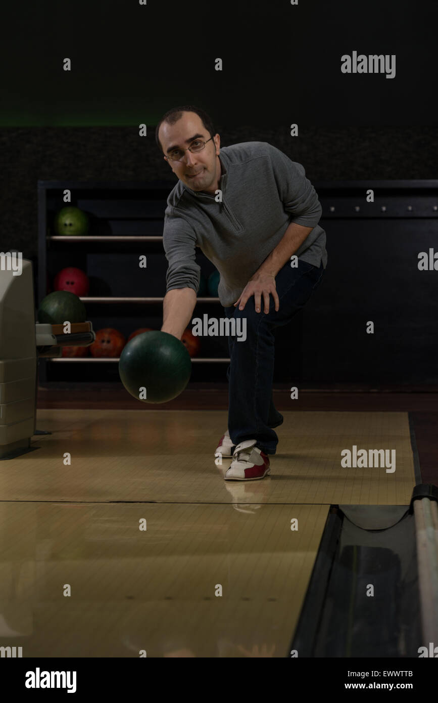 Smiling Young Man Playing With A Bowling Ball Stock Photo - Alamy