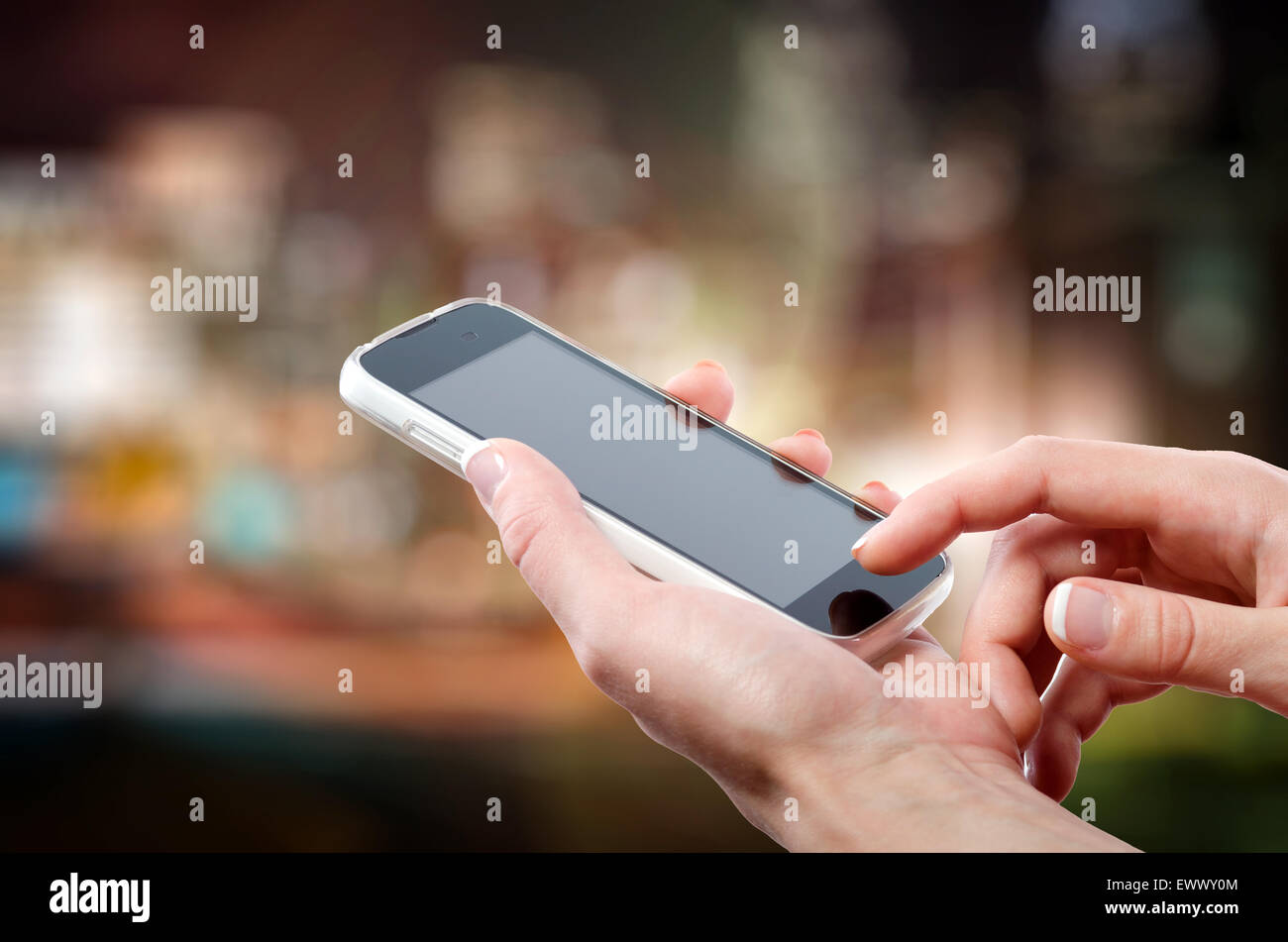 Female hands holding a cell phone (smartphone) with tuchscreen in night ...