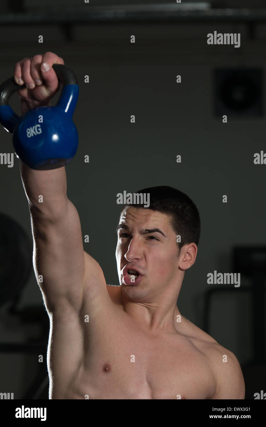 Muscular Man Exercise with Kettle Bell Stock Photo - Alamy
