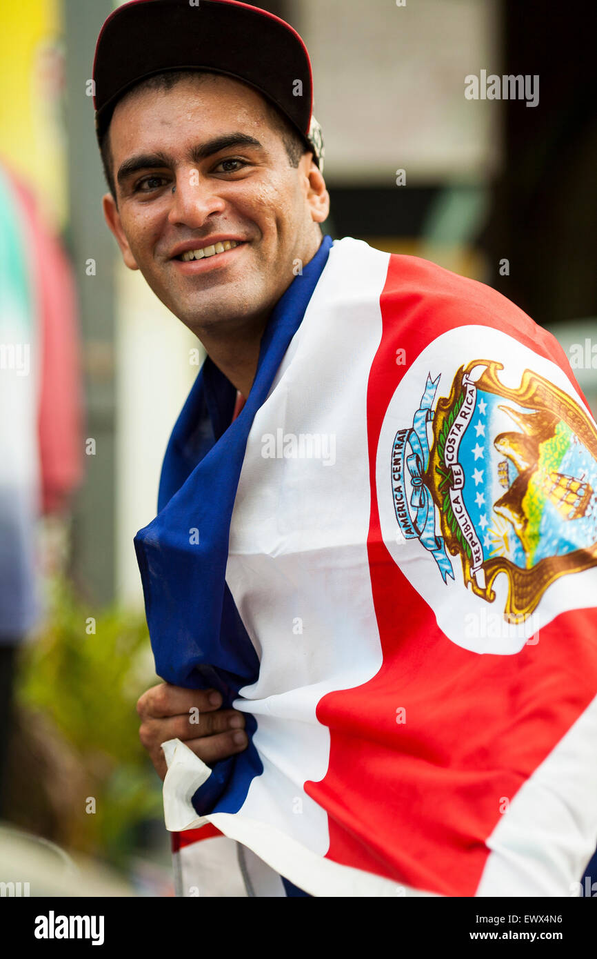 A fanatical Tico football fan draped in the national flag celebrates ...