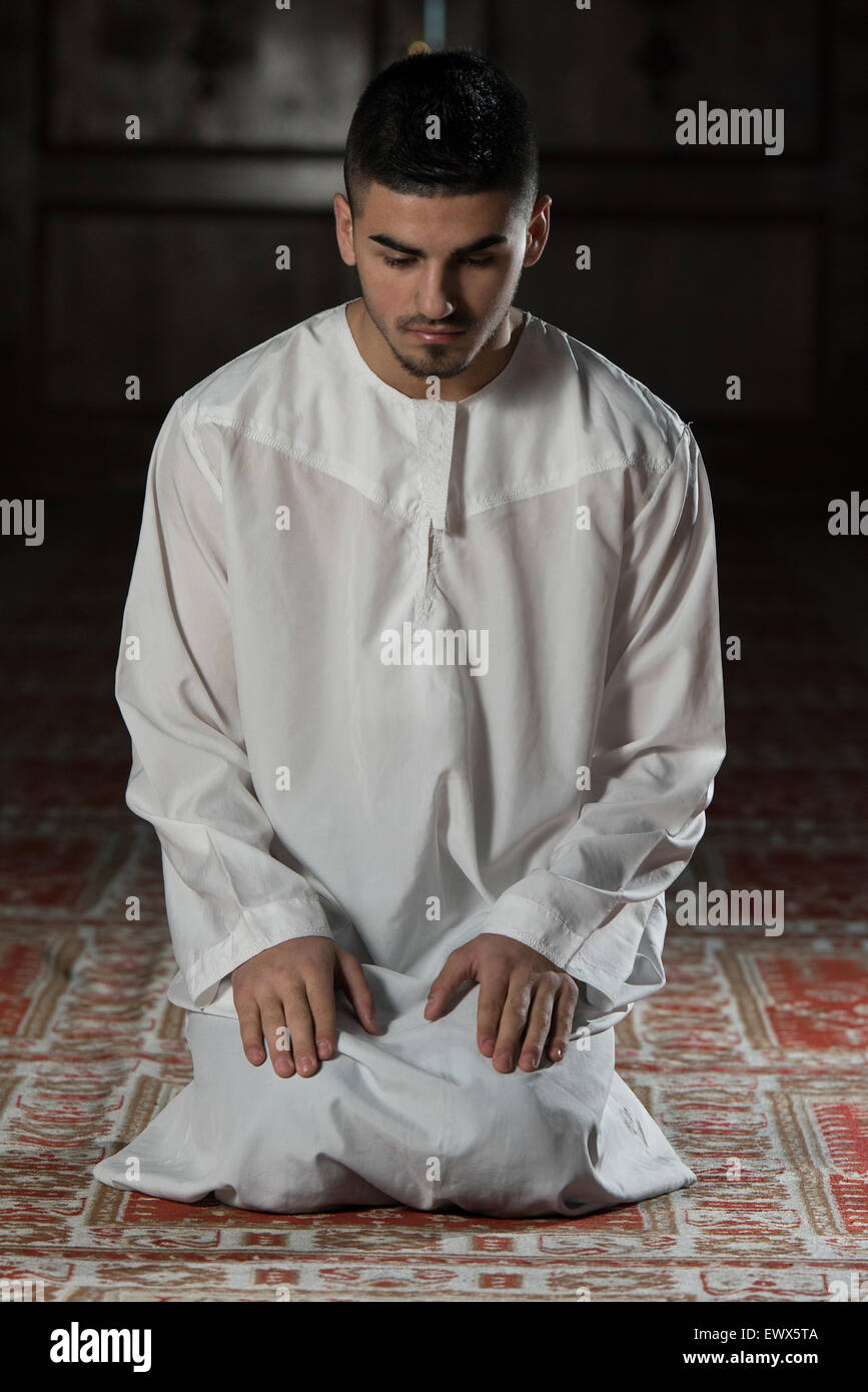 Young Muslim Man Making Traditional Prayer To God While Wearing A ...