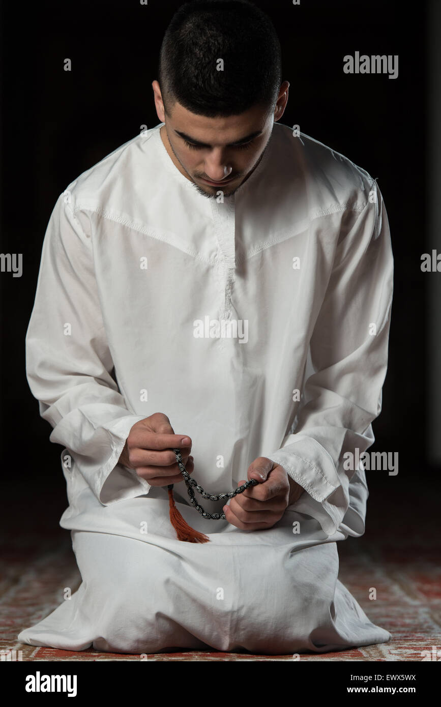 Young Muslim Man Making Traditional Prayer To God While Wearing A ...