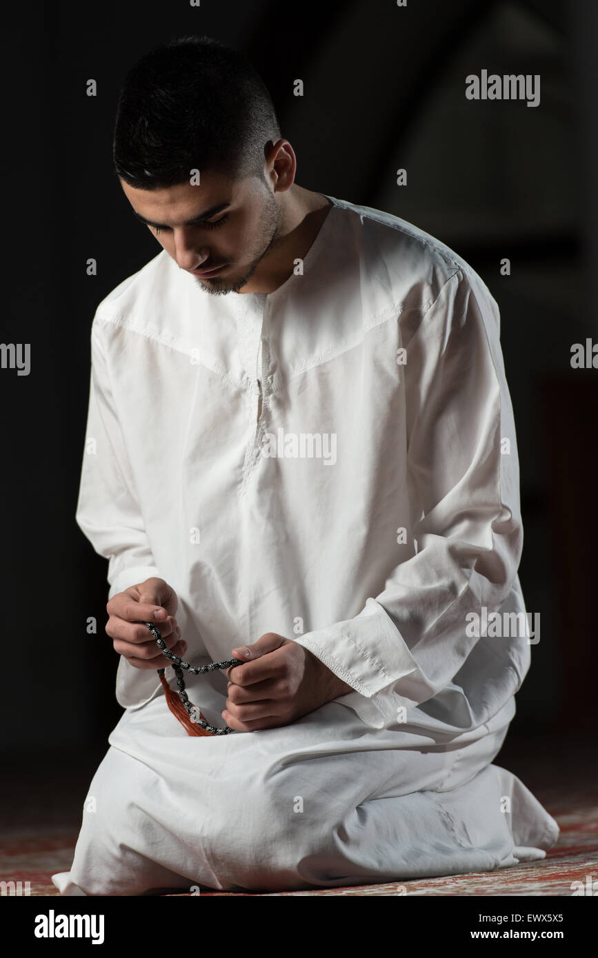 Young Muslim Man Making Traditional Prayer To God While Wearing A ...
