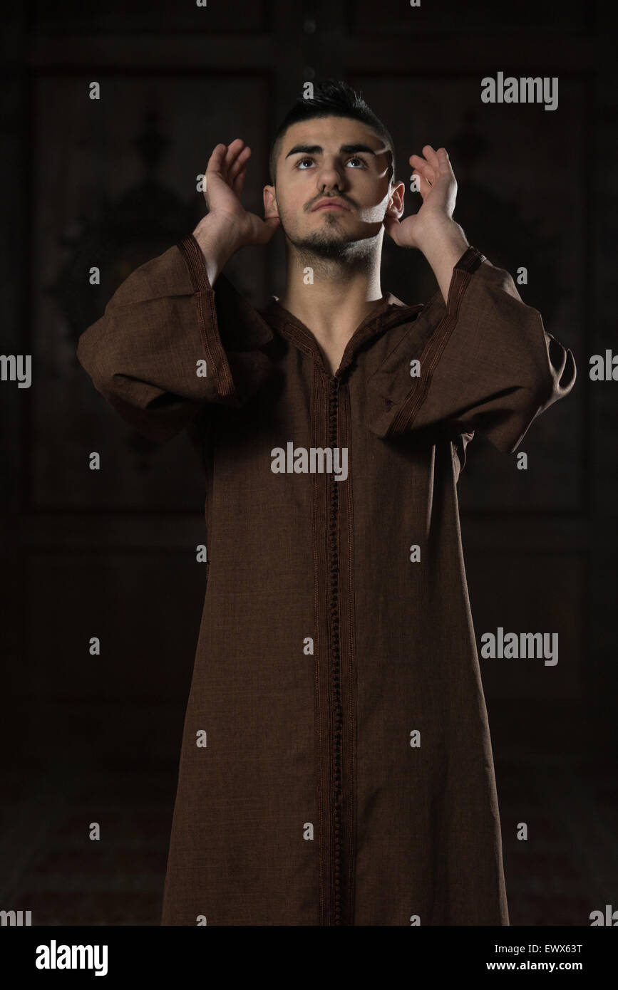 Young Muslim Man Making Traditional Prayer To God While Wearing A ...
