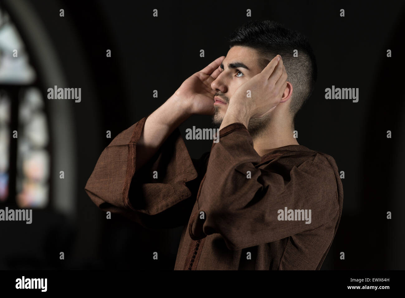 Young Muslim Man Making Traditional Prayer To God While Wearing A ...
