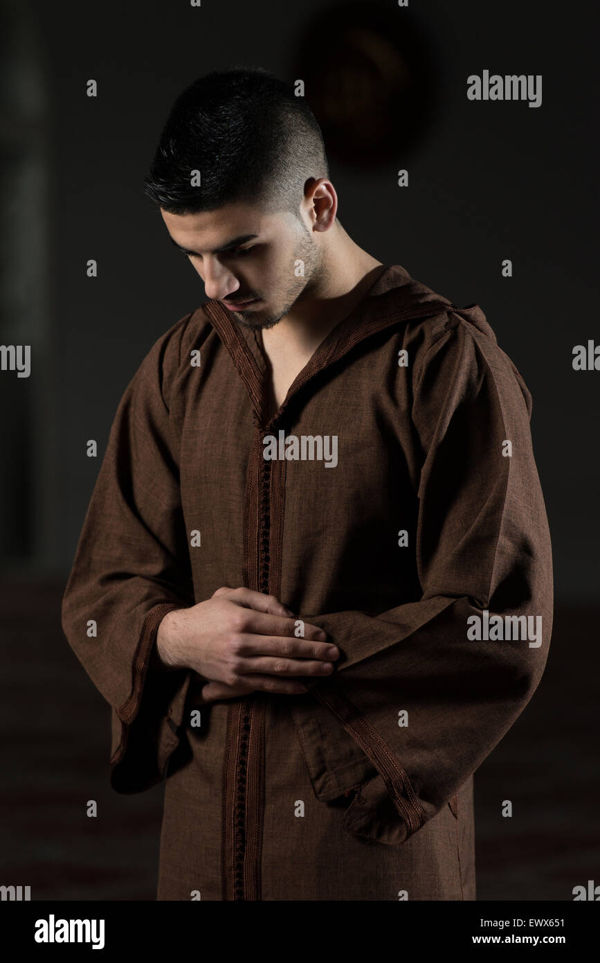 Young Muslim Man Making Traditional Prayer To God While Wearing A ...