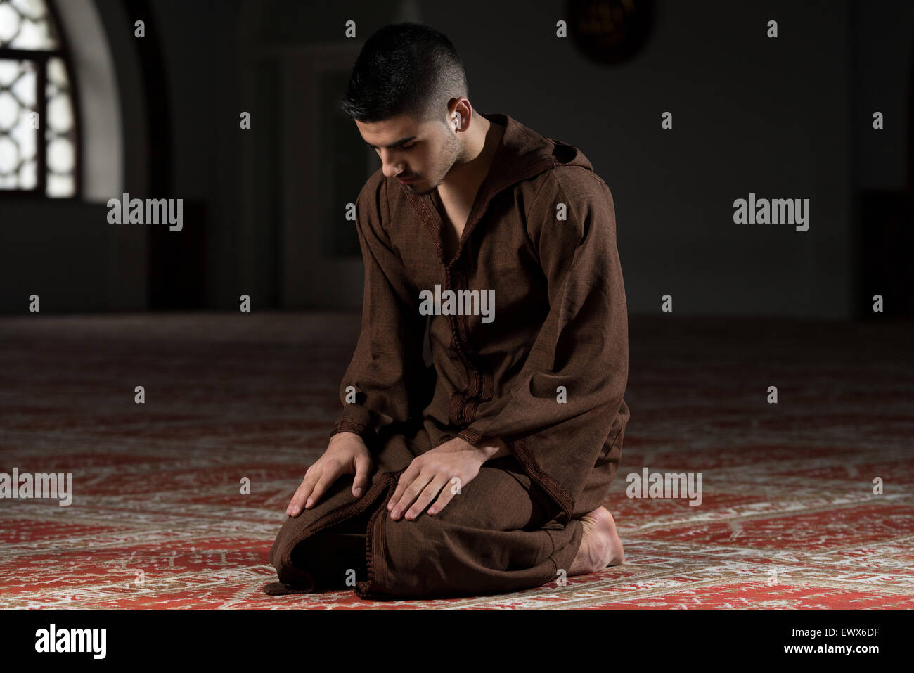 Young Muslim Man Making Traditional Prayer To God While Wearing A ...