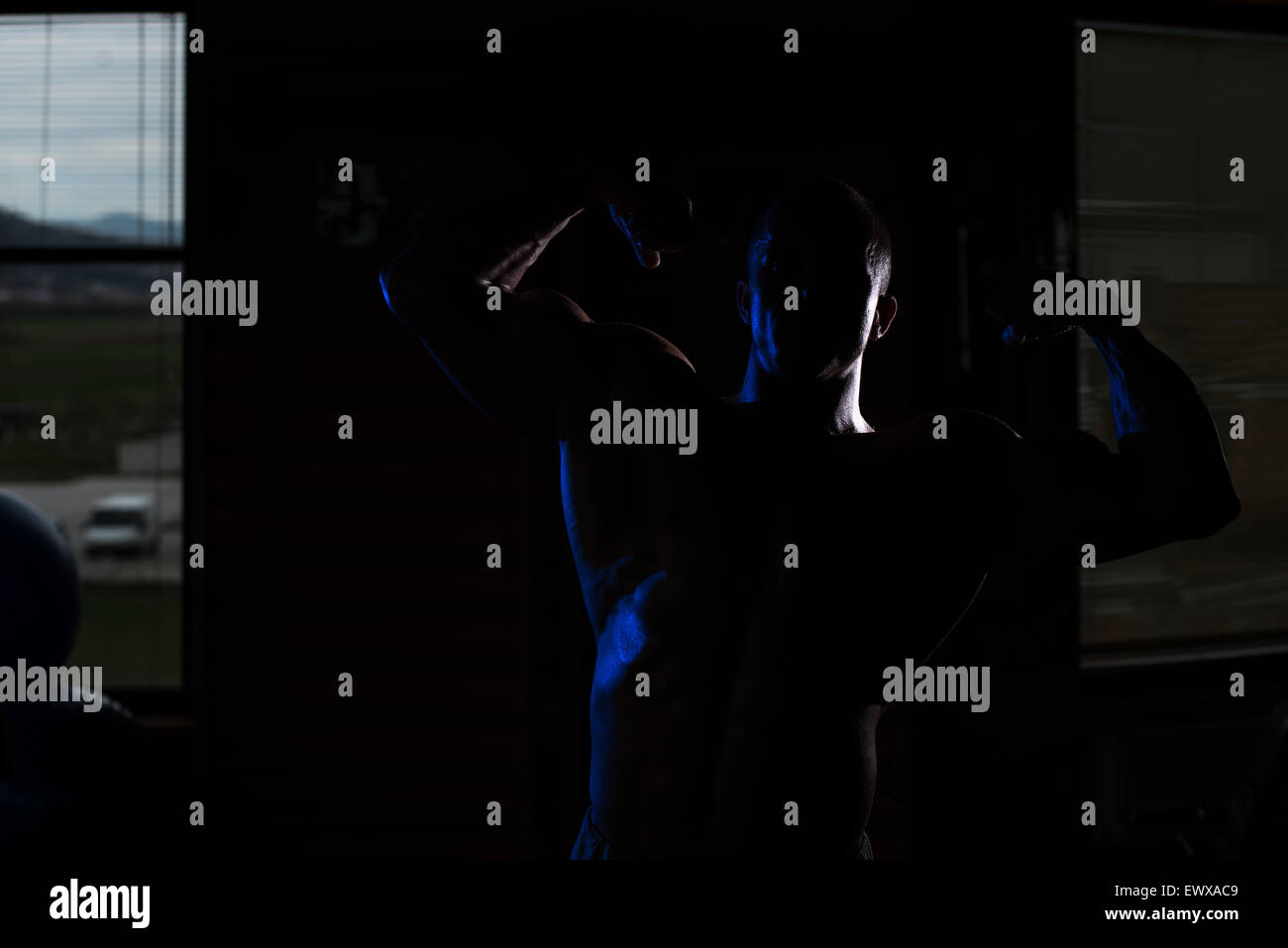 siluet Young Muscular Man Flexing Muscles Stock Photo - Alamy