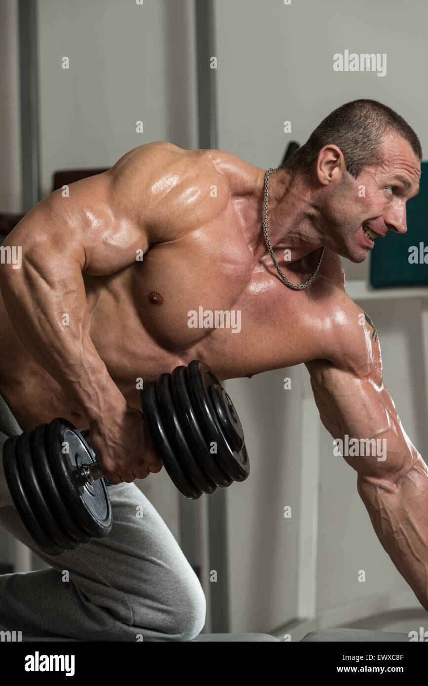 Healthy Man Doing Back Exercises In The Gym With Dumbbell Stock Photo ...