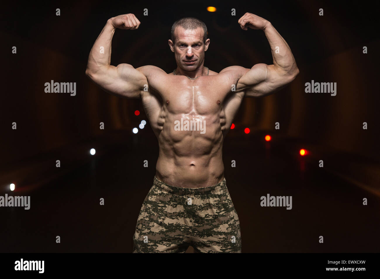 Bodybuilder Performing Front Double Biceps Poses In Tunnel Stock Photo ...