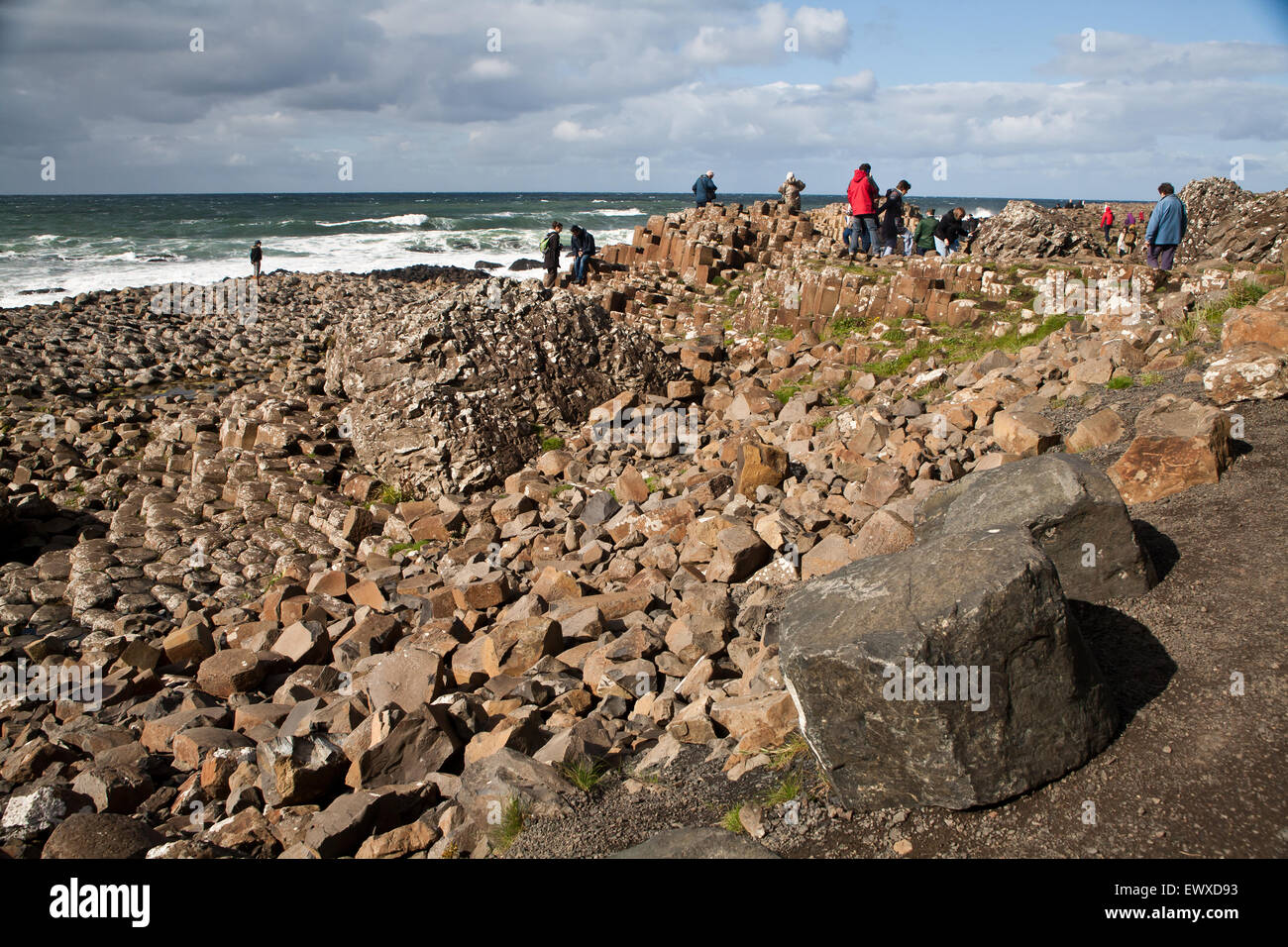 People clambering over rocks at the Giant's Causeway, Northern Ireland ...