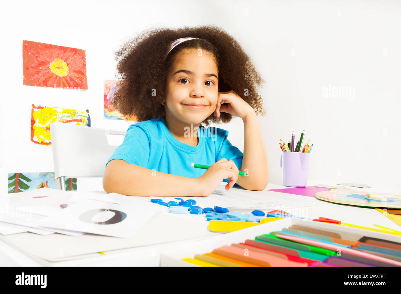 African girl writes letters sitting at table Stock Photo - Alamy