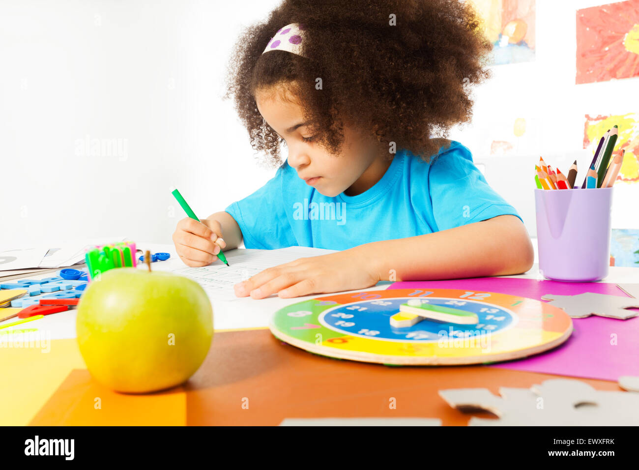 Small girl sits at the table and writing letters Stock Photo - Alamy