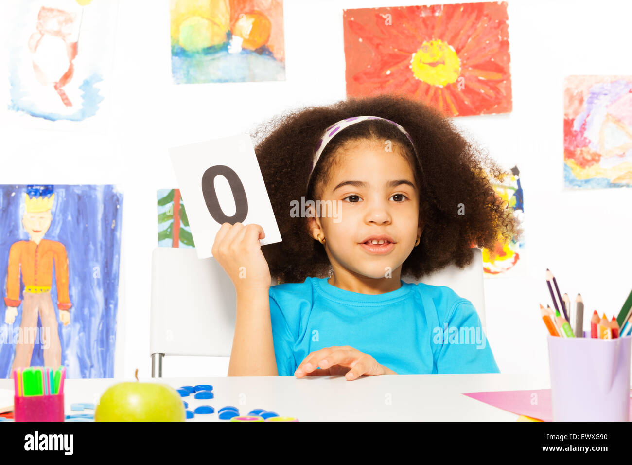 African girl holds flashcard with zero at desk Stock Photo - Alamy