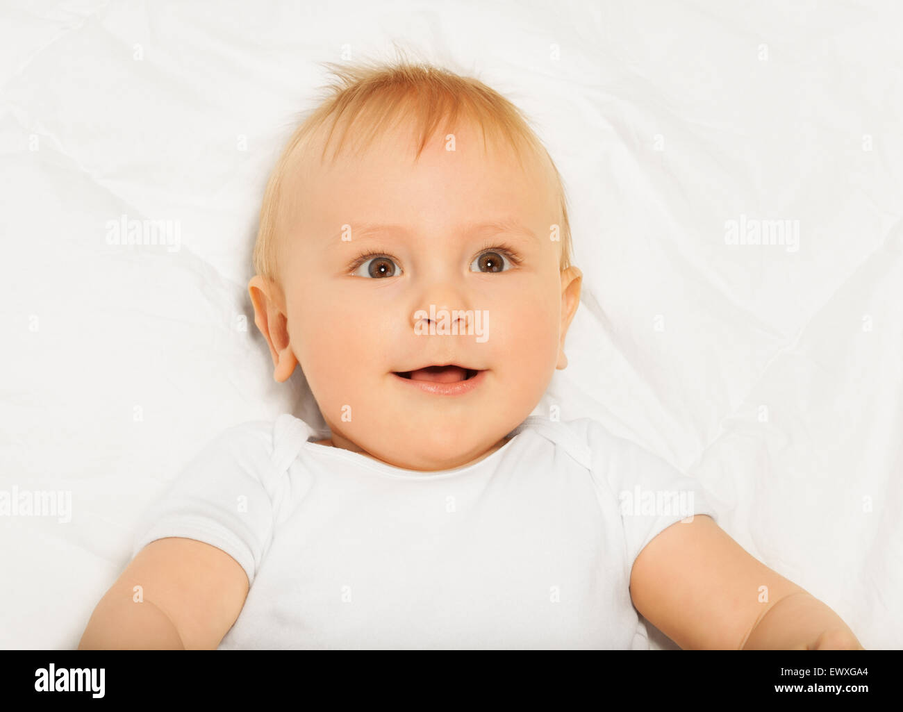 Amazed face of small baby wearing white babygro Stock Photo - Alamy