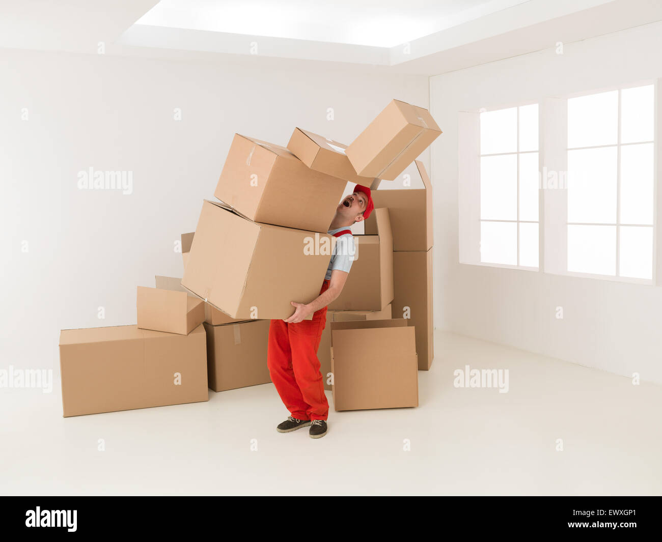 deliveryman holding stack of parcels and dropping some of them Stock ...