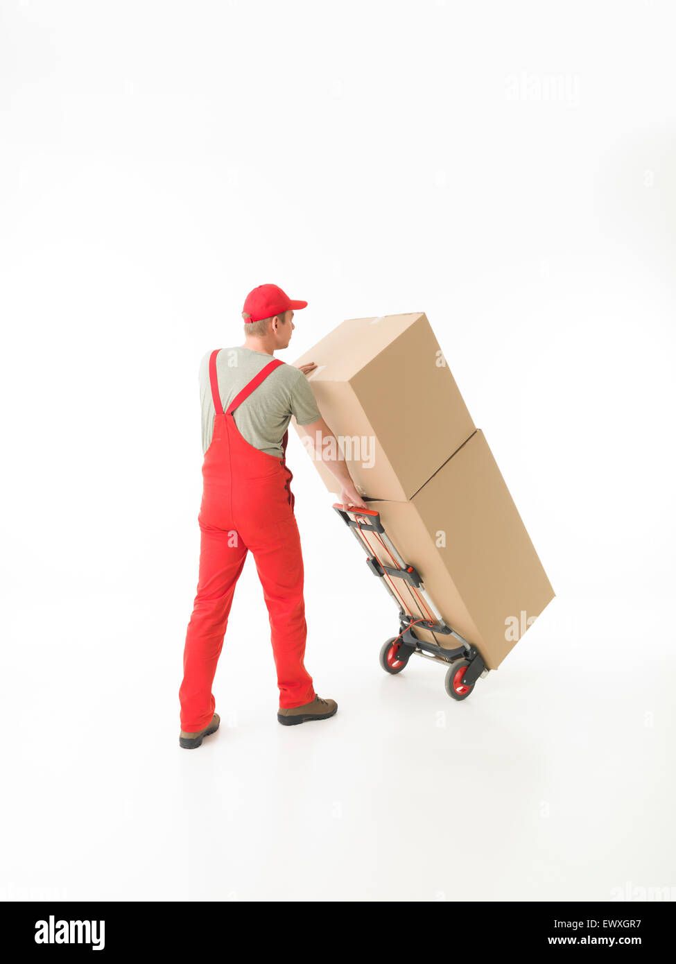 rear view of delivery man holding push cart loaded with cardboard boxes ...