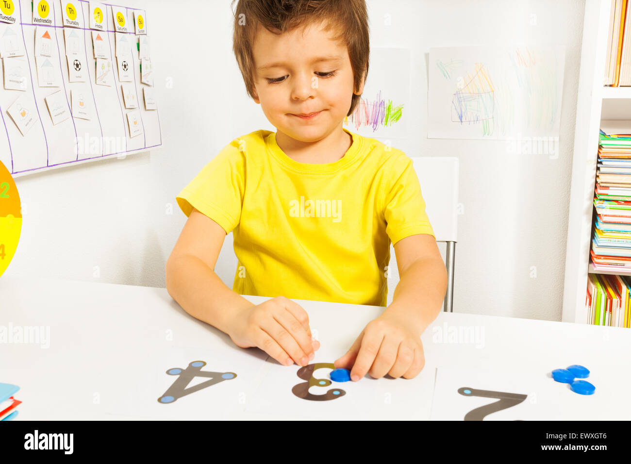 Smiling boy put coins on numbers learning count Stock Photo - Alamy