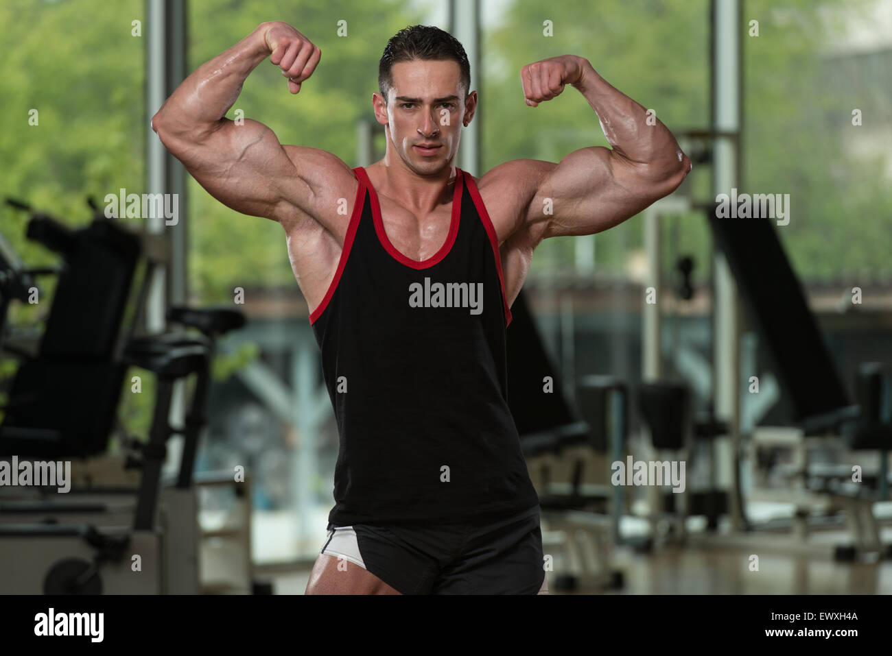 Serious Men Standing In The Gym And Flexing Muscles Stock Photo - Alamy