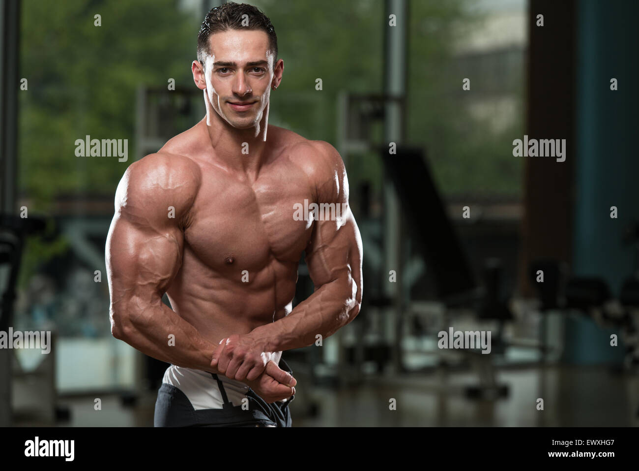 Serious Men Standing In The Gym And Flexing Muscles Stock Photo - Alamy