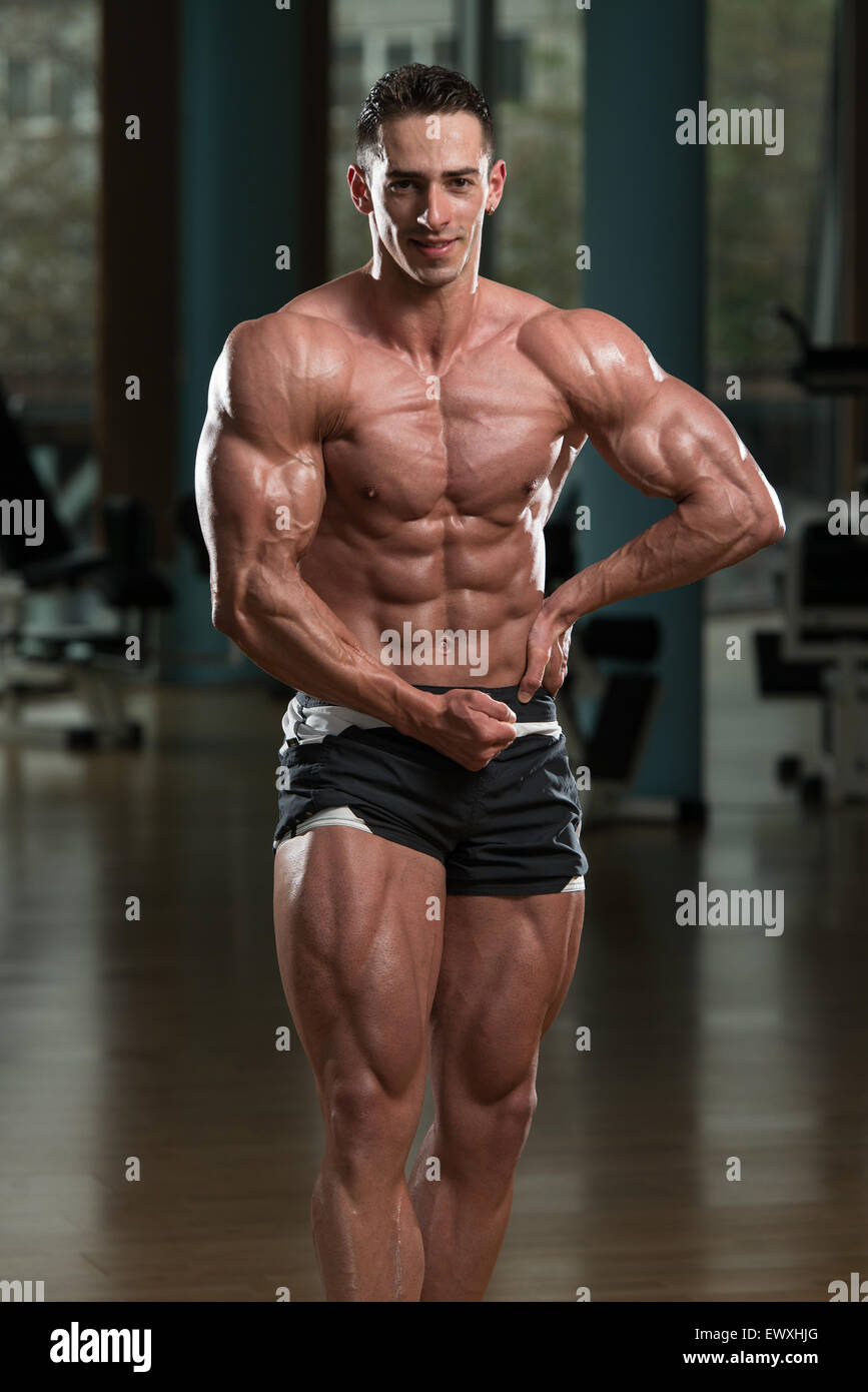 Serious Men Standing In The Gym And Flexing Muscles Stock Photo - Alamy