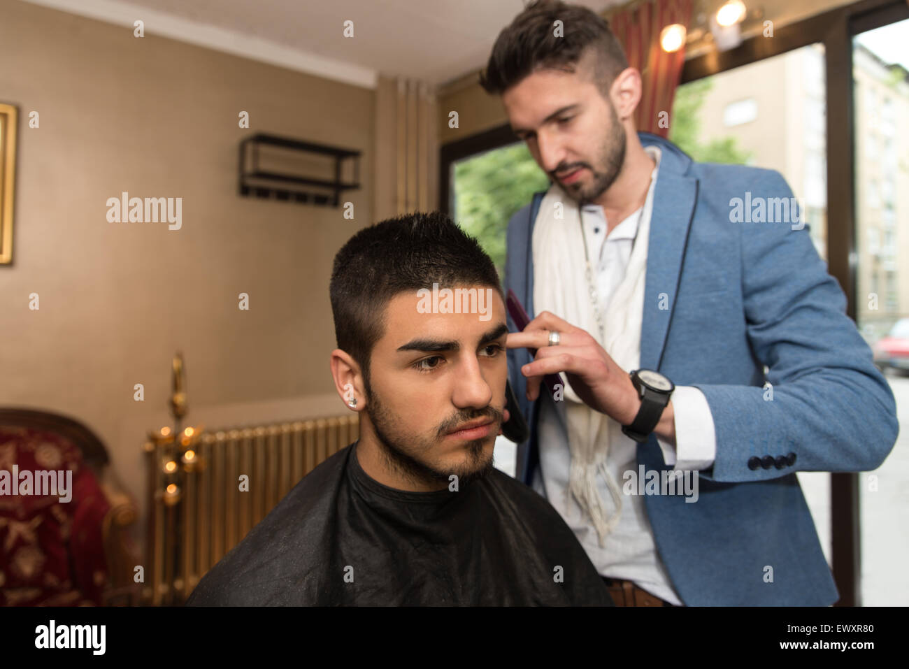 Handsome Young Hairdresser Giving A New Haircut To Male Customer At ...