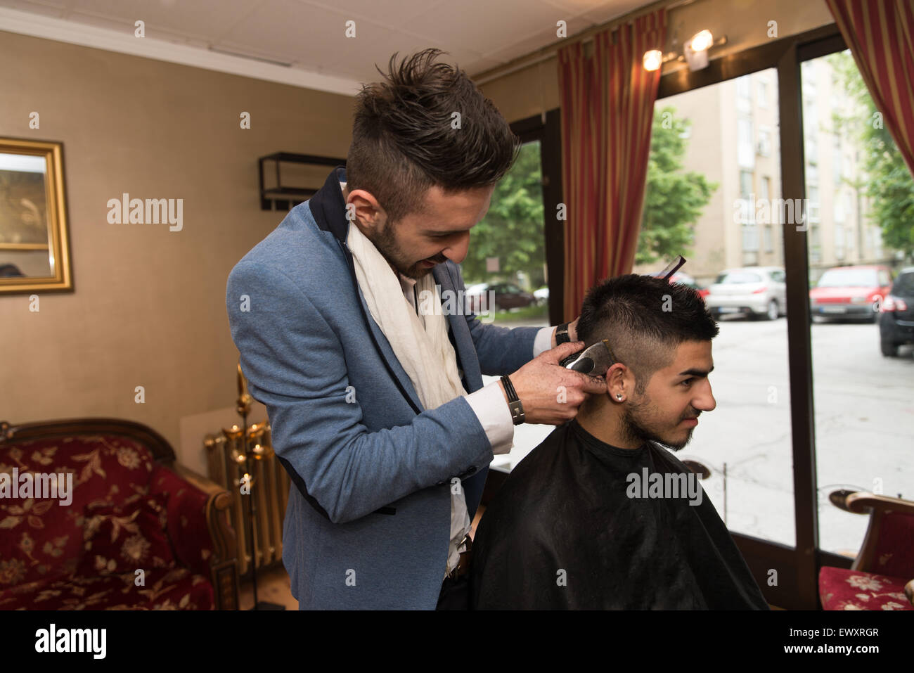 Handsome Young Hairdresser Giving A New Haircut To Male Customer At ...