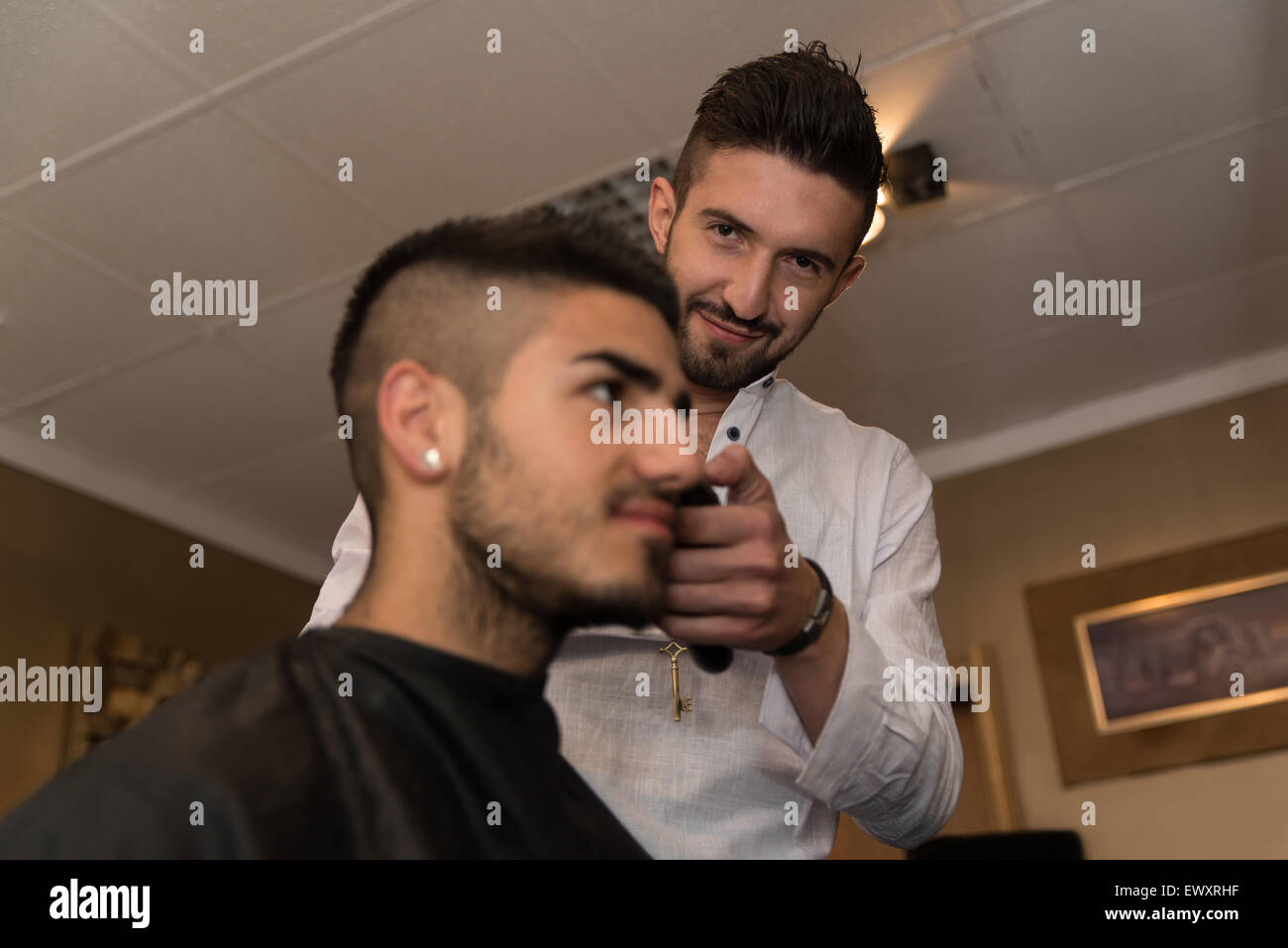 Handsome Young Hairdresser Giving A New Haircut To Male Customer At ...