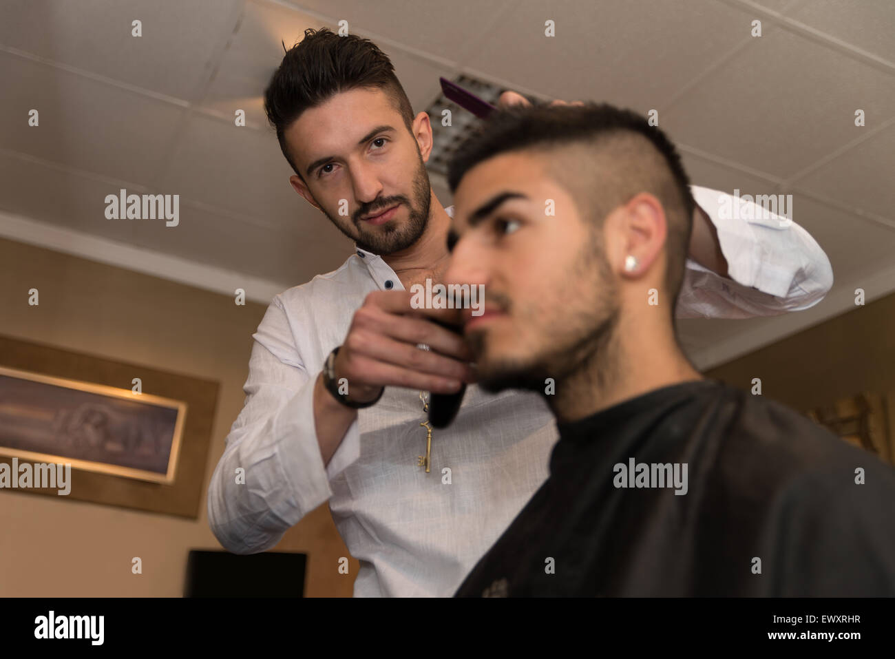 Handsome Young Hairdresser Giving A New Haircut To Male Customer At ...