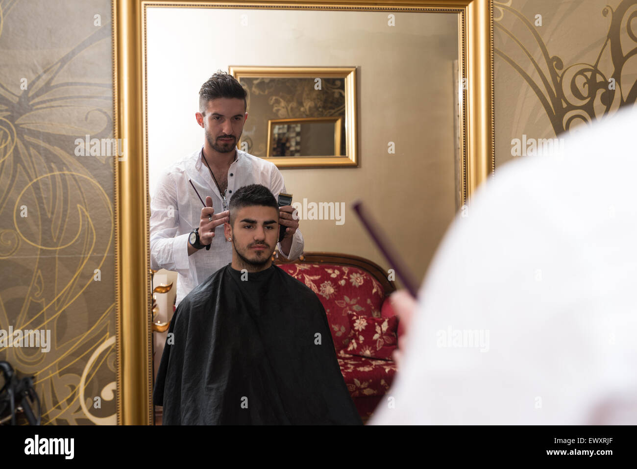 Handsome Young Hairdresser Giving A New Haircut To Male Customer At ...