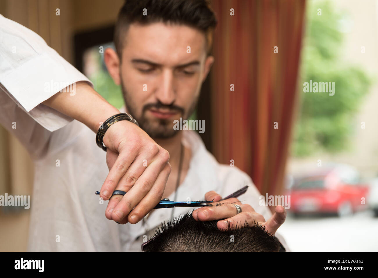 Handsome Young Hairdresser Giving A New Haircut To Male Customer At ...