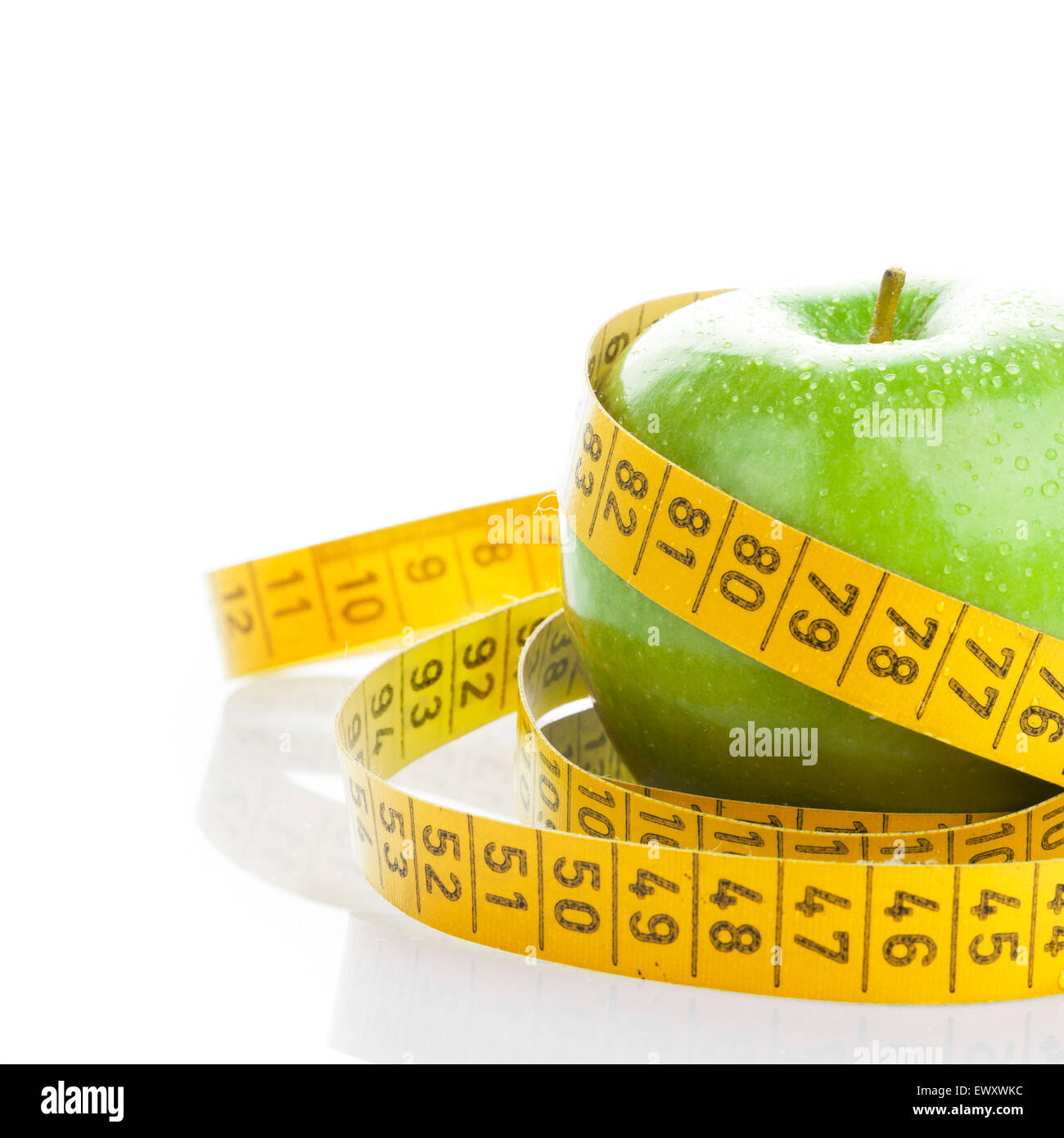 Green apple with measuring tape on white background Stock Photo - Alamy