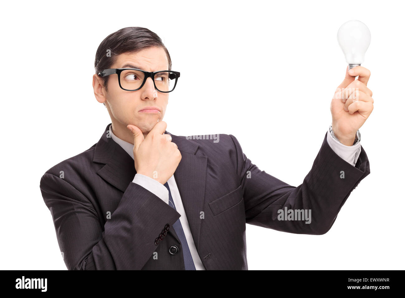 Young businessman looking at a light bulb and thinking isolated on ...