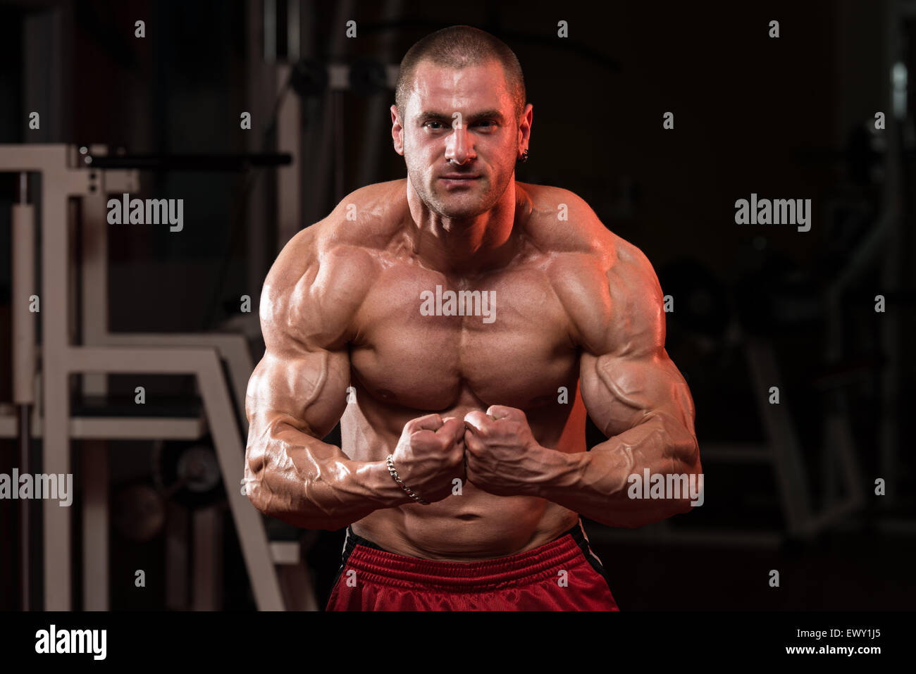Serious Bodybuilder Standing In The Gym And Flexing Muscles Stock Photo ...