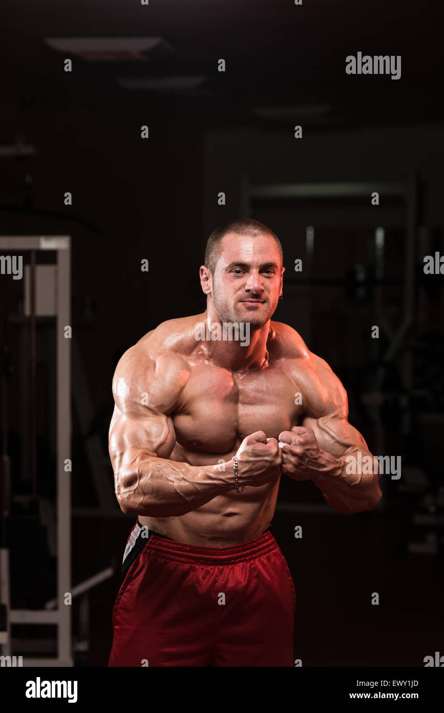 Serious Bodybuilder Standing In The Gym And Flexing Muscles Stock Photo ...