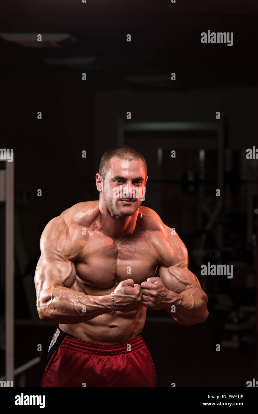 Serious Bodybuilder Standing In The Gym And Flexing Muscles Stock Photo ...