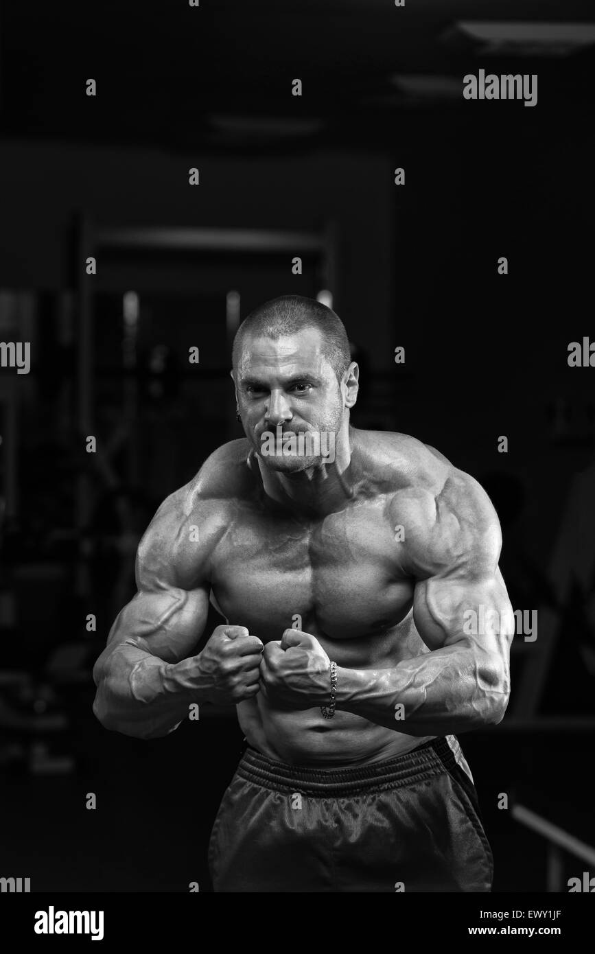 Serious Bodybuilder Standing In The Gym And Flexing Muscles Stock Photo ...