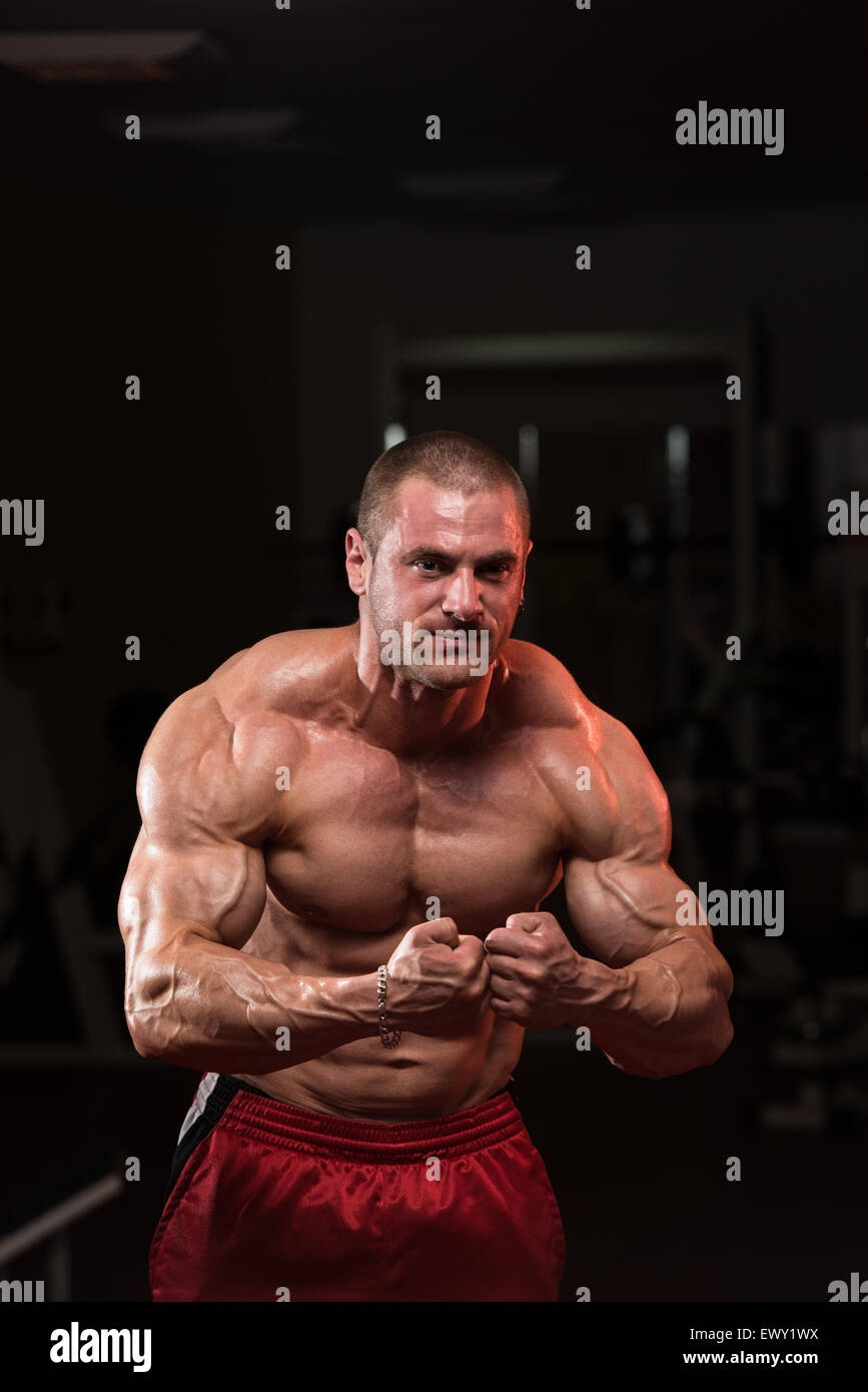 Serious Bodybuilder Standing In The Gym And Flexing Muscles Stock Photo ...