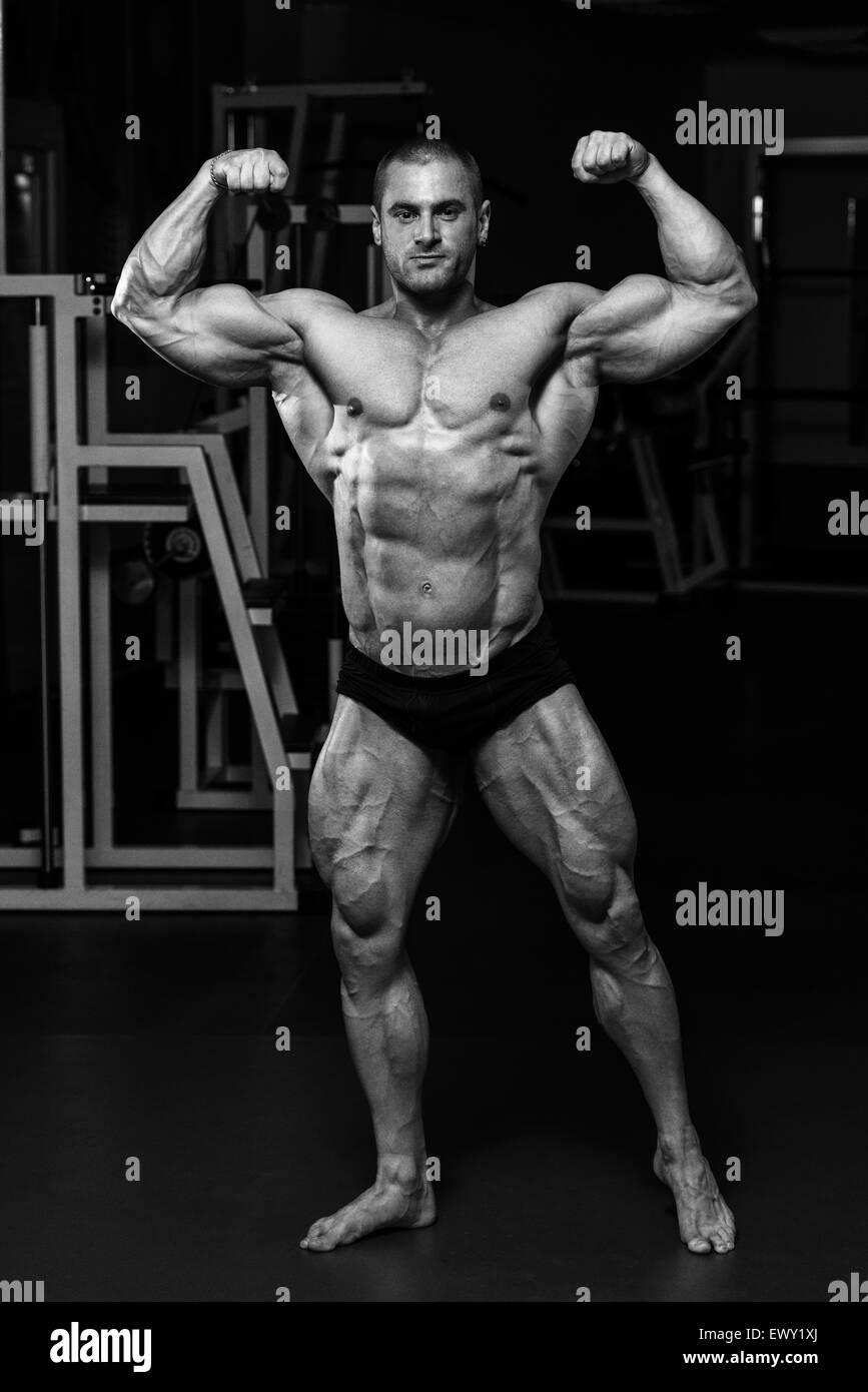 Serious Bodybuilder Standing In The Gym And Flexing Muscles Stock Photo ...
