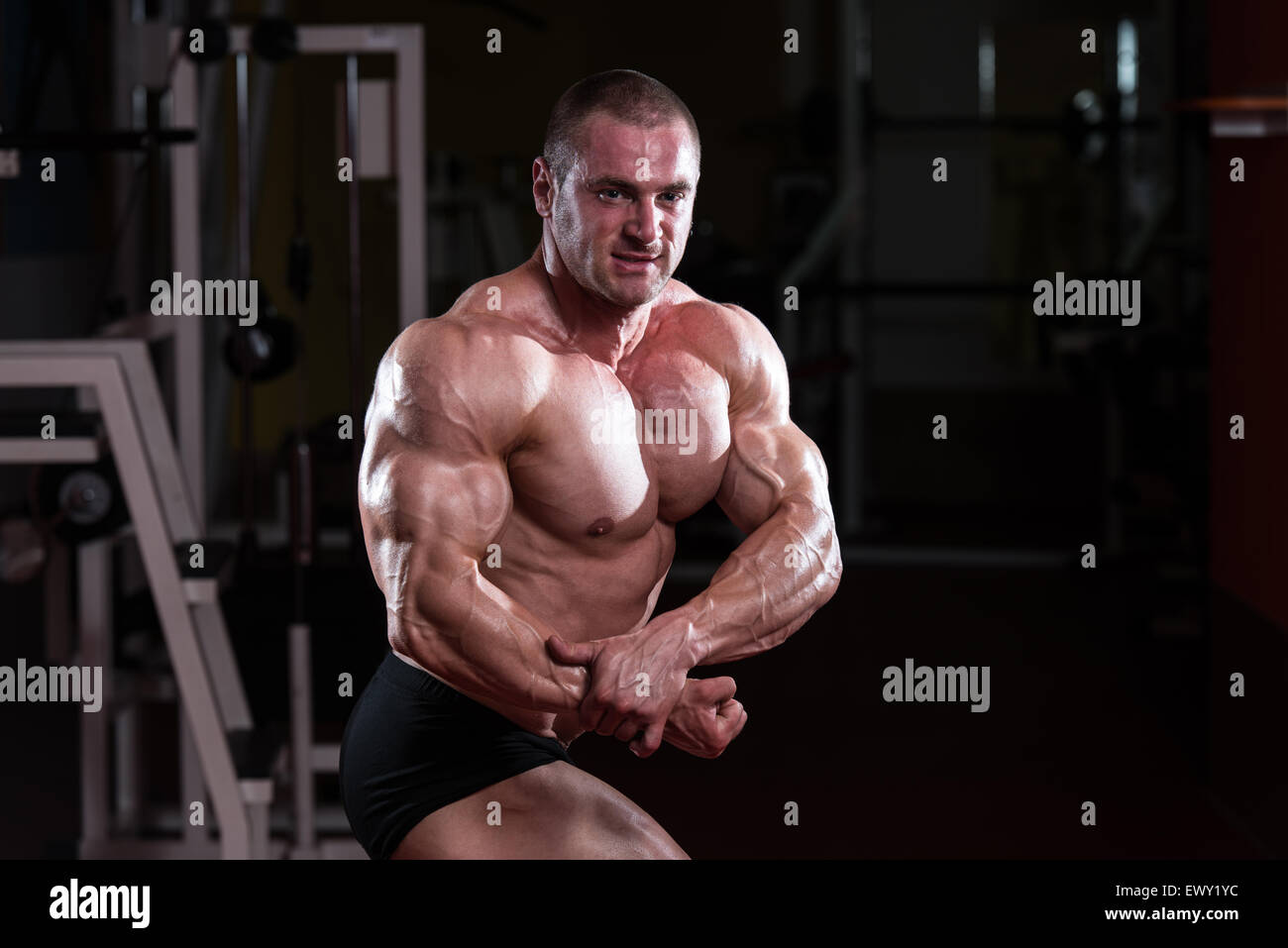 Serious Bodybuilder Standing In The Gym And Flexing Muscles Stock Photo ...