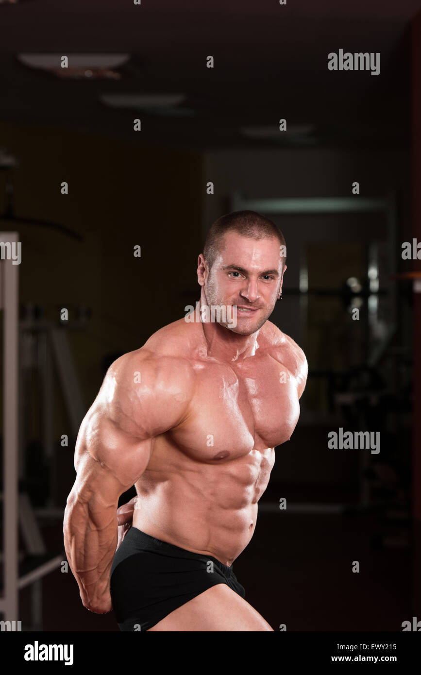 Serious Bodybuilder Standing In The Gym And Flexing Muscles Stock Photo ...