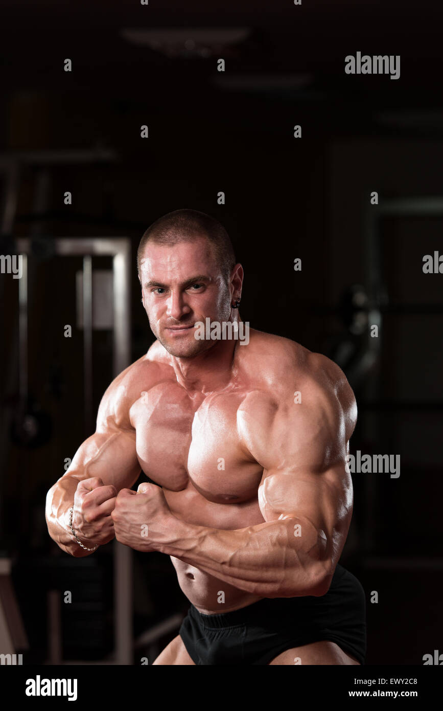 Serious Bodybuilder Standing In The Gym And Flexing Muscles Stock Photo ...