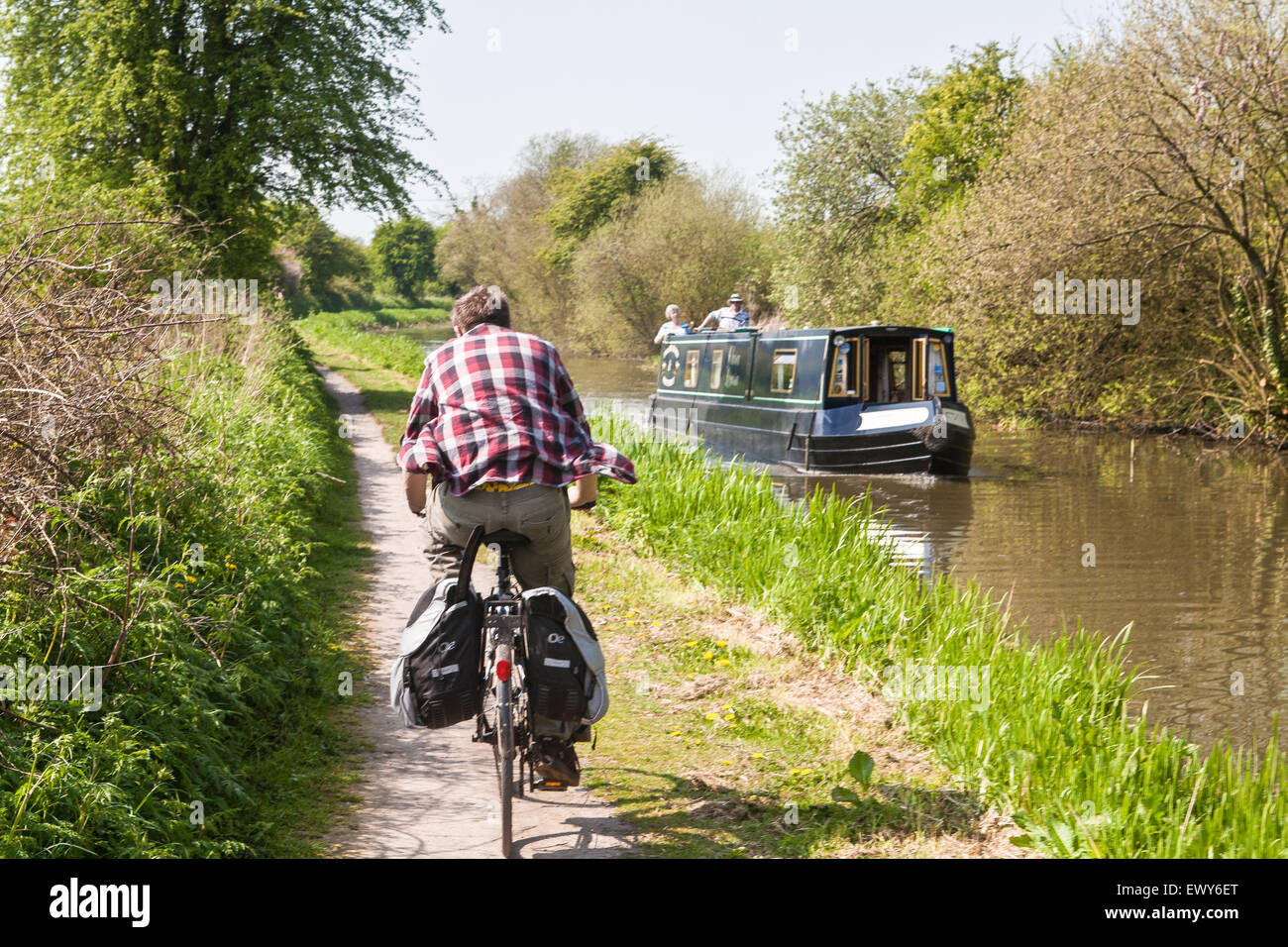 Cyclist cycling along canal side and narrowboat. Part of the Kennet and ...