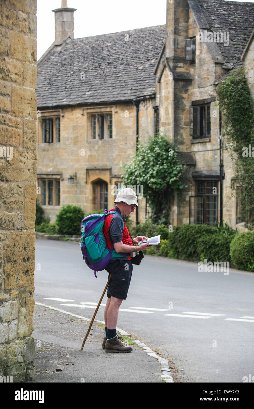 Hiker checking directions in Stanton village with honey coloured ...
