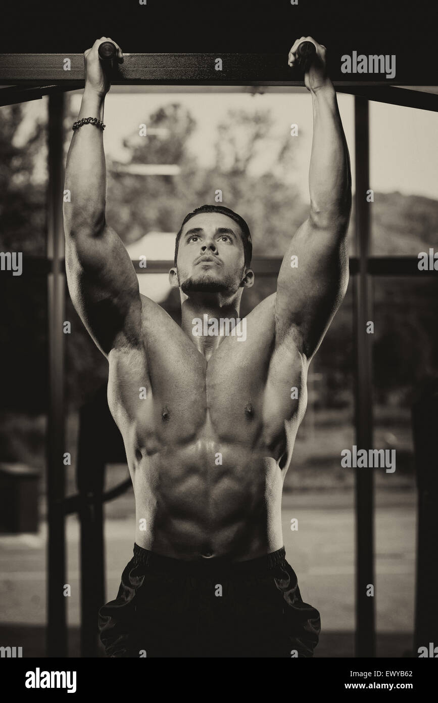 Young Man Performing Hanging Leg Raises Exercise - One Of The Most ...