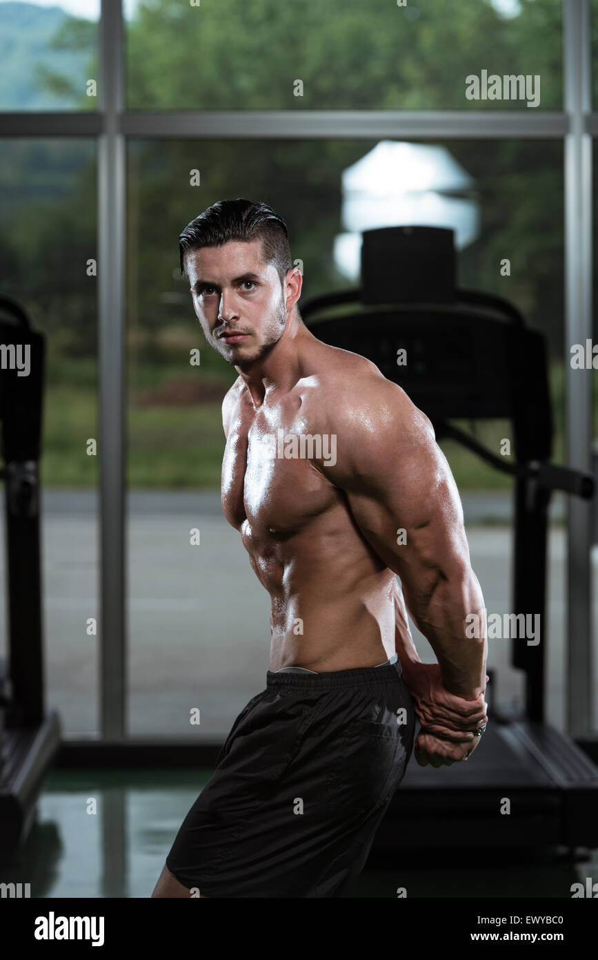 Serious Man Bodybuilder Standing In The Gym And Flexing Muscles Stock ...