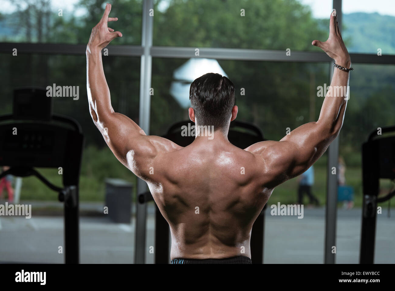Serious Man Bodybuilder Standing In The Gym And Flexing Muscles Stock ...
