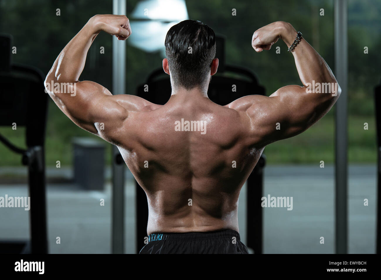 Serious Man Bodybuilder Standing In The Gym And Flexing Muscles Stock ...